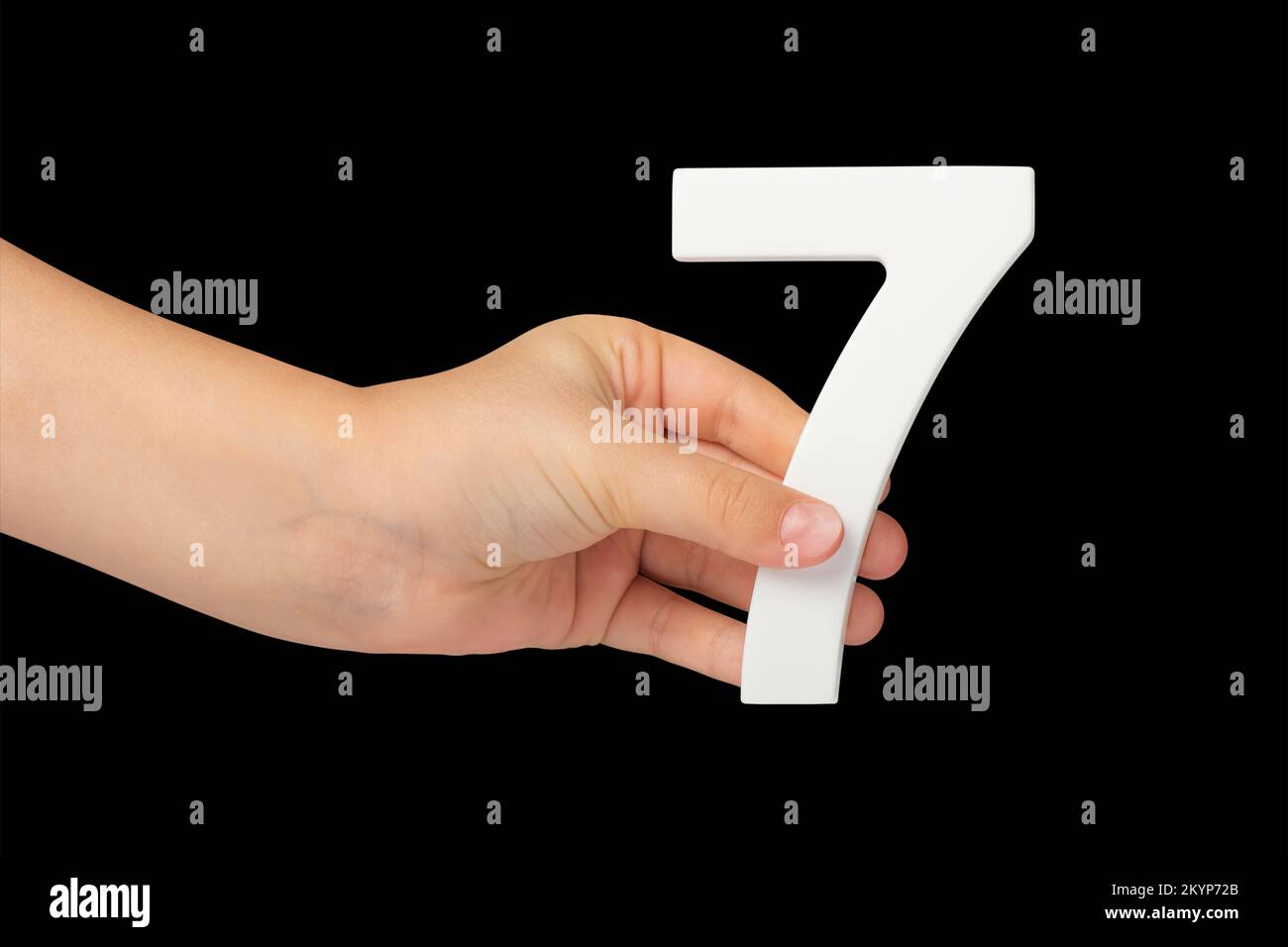 Number seven in hand isolated on black background. Number 7 in a child ...