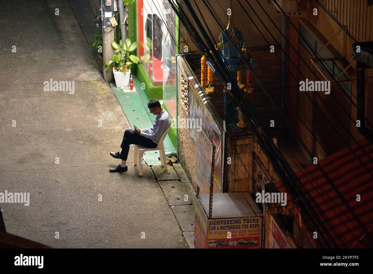 An Indian tailor waiting for customers outside his shop in Hua Hin ...