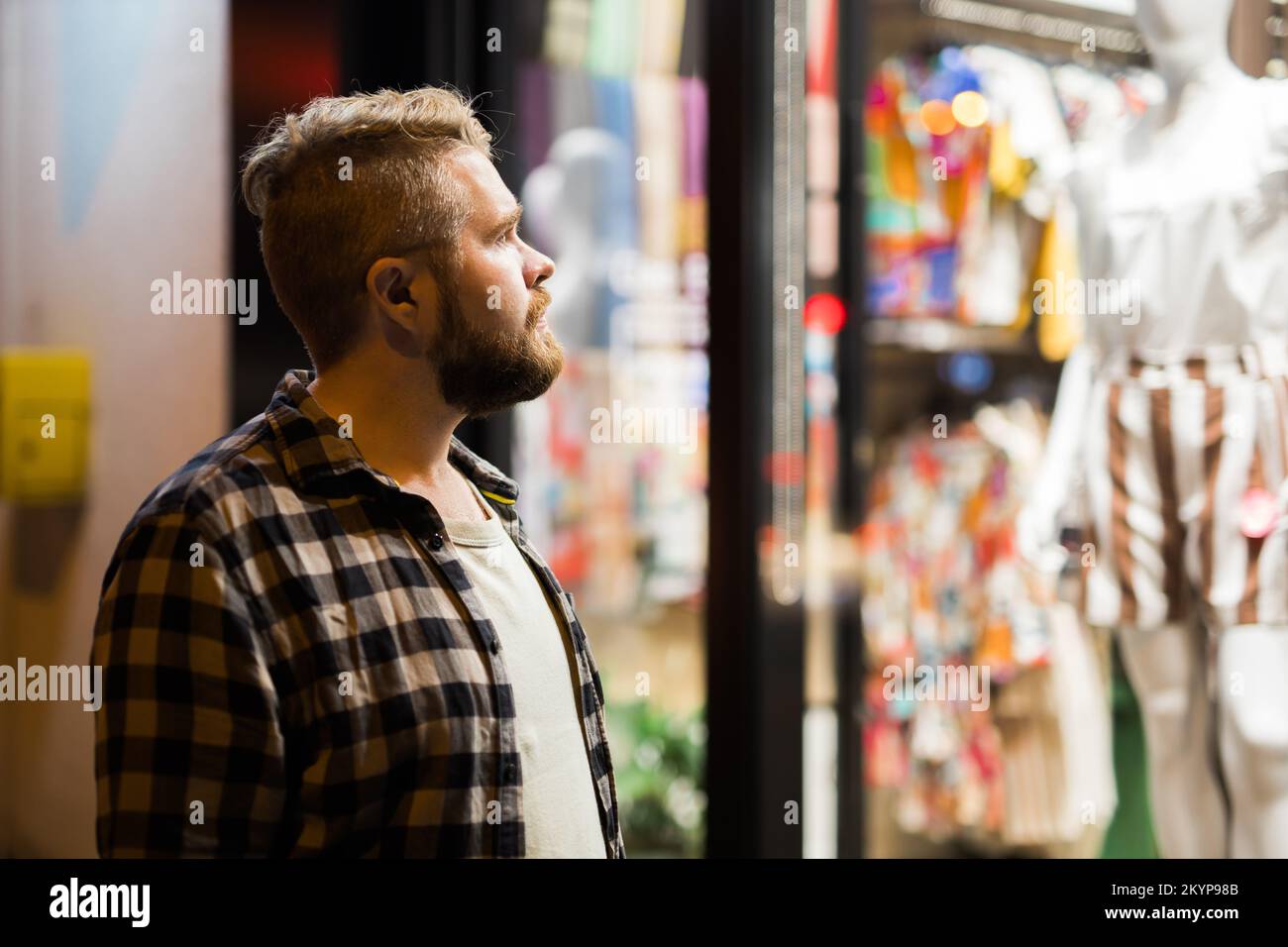 Man looking at shop window in evening street - store and shopaholic ...