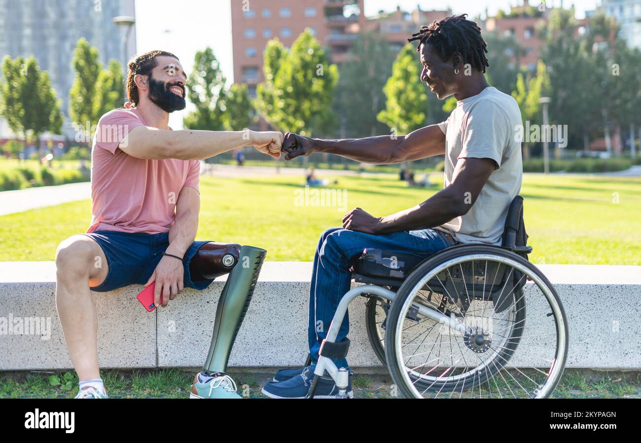 Two disabled friends give fist bump as a sign of friendship and ...