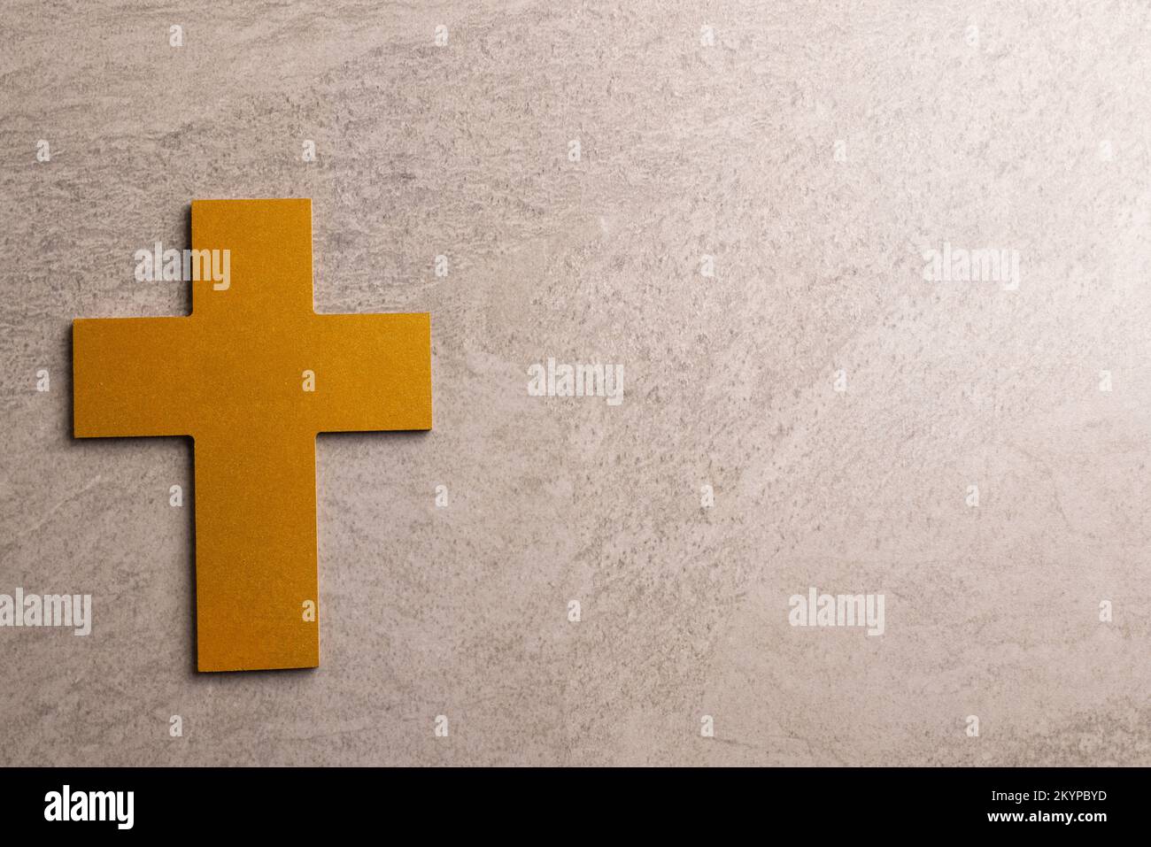Image of close up of yellow wooden cross and copy space on grey ...