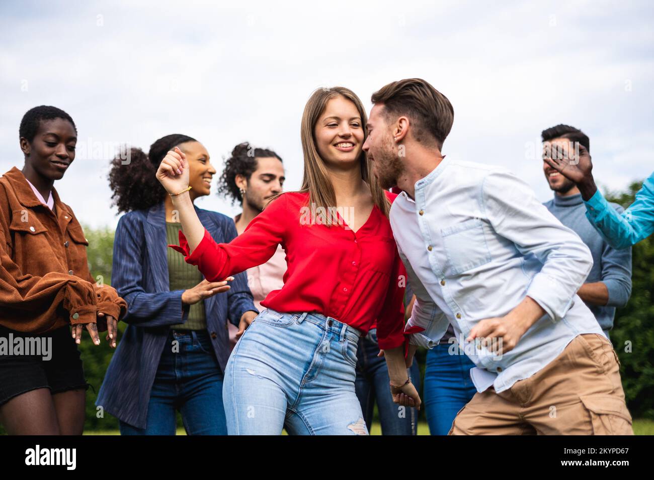 Lateral view of multiracial group of friends dancing together on the ...