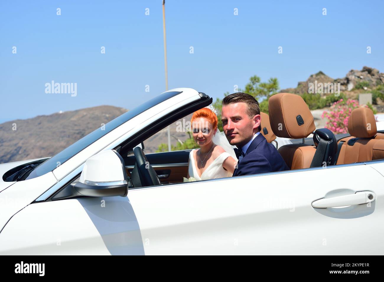 Beautiful young couple bride and groom posing in the white car on ...