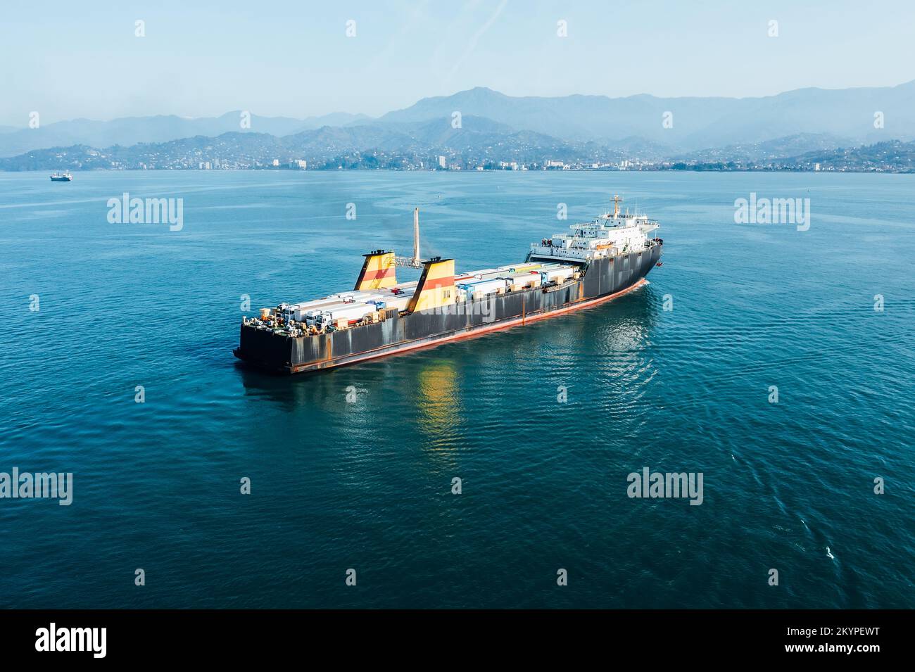 Freight cargo ship with trucks and containers in sea, aerial view from ...