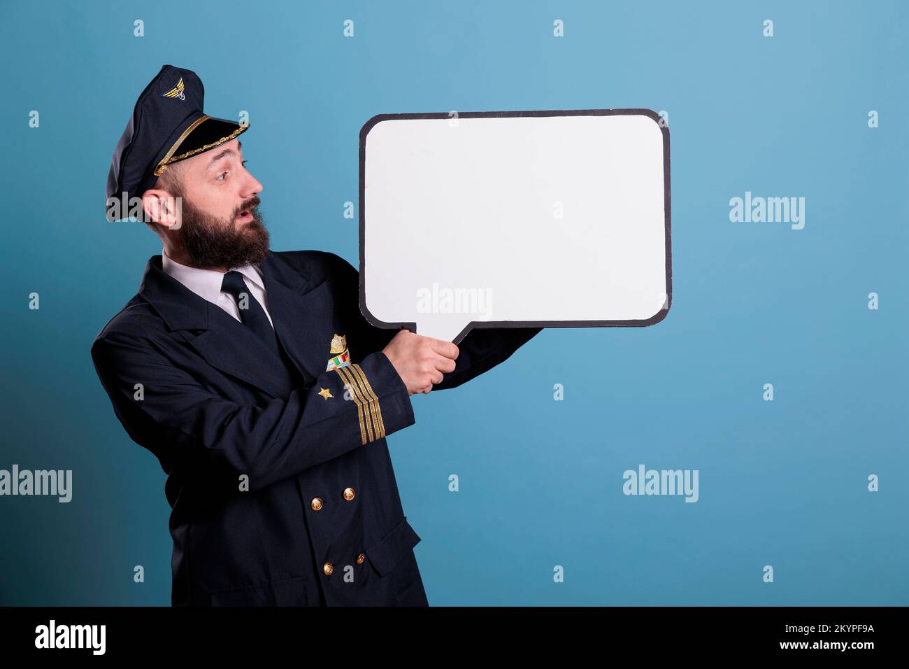 Surprised airplane capitan holding white empty speech bubble with copy ...