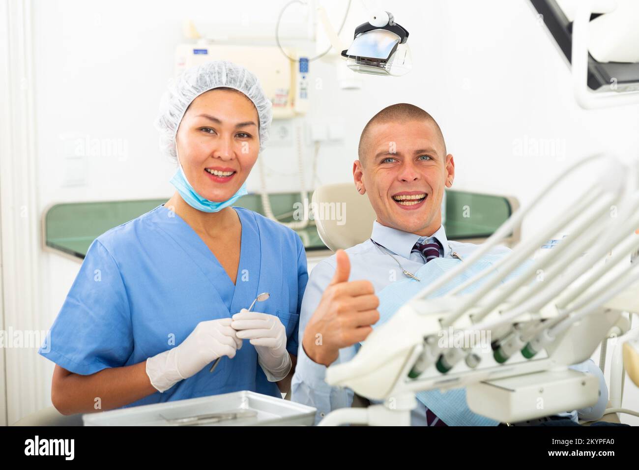 Satisfied patient visiting dentist giving thumbs up Stock Photo - Alamy
