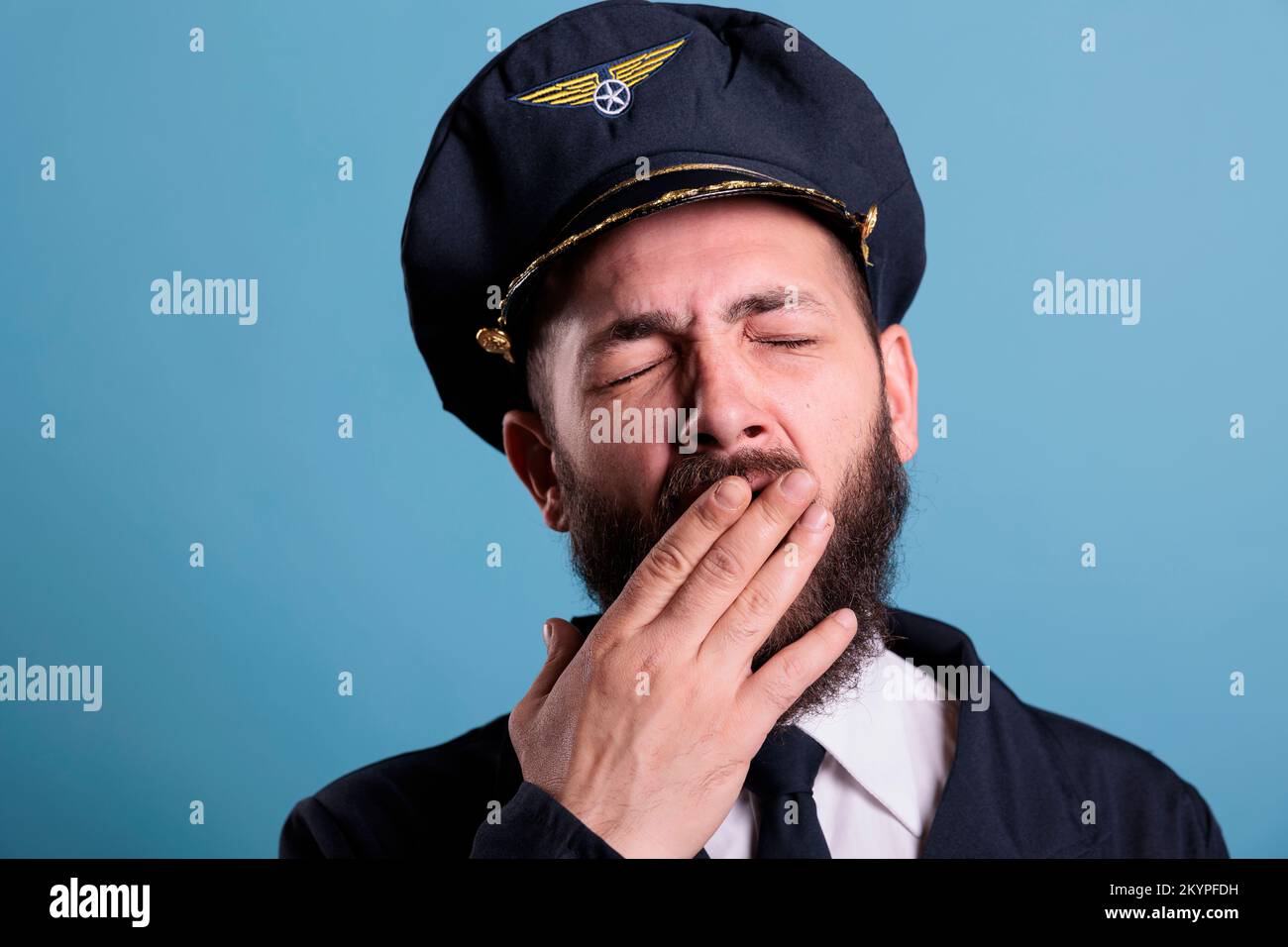 Tired airplane pilot yawning closeup, exhausted aviator covering open ...