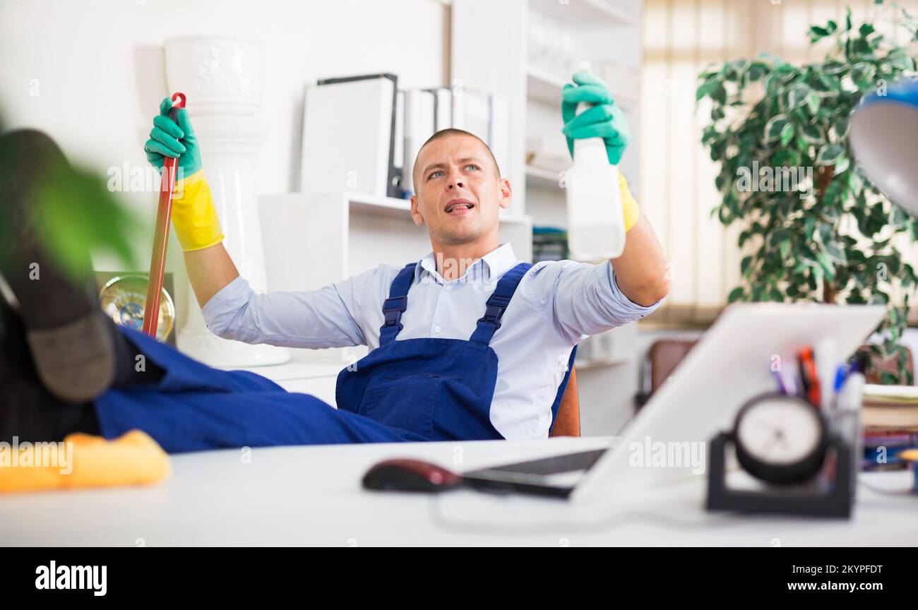 Office cleaner is resting in chair instead of cleaning office Stock ...