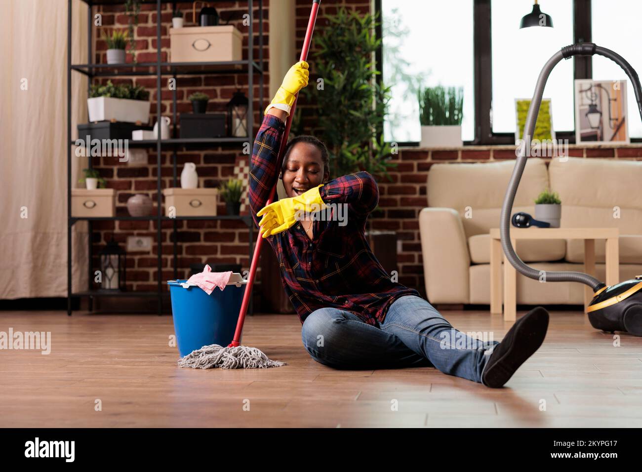 Stressed woman cleaning work sitting on the floor with no strength to ...