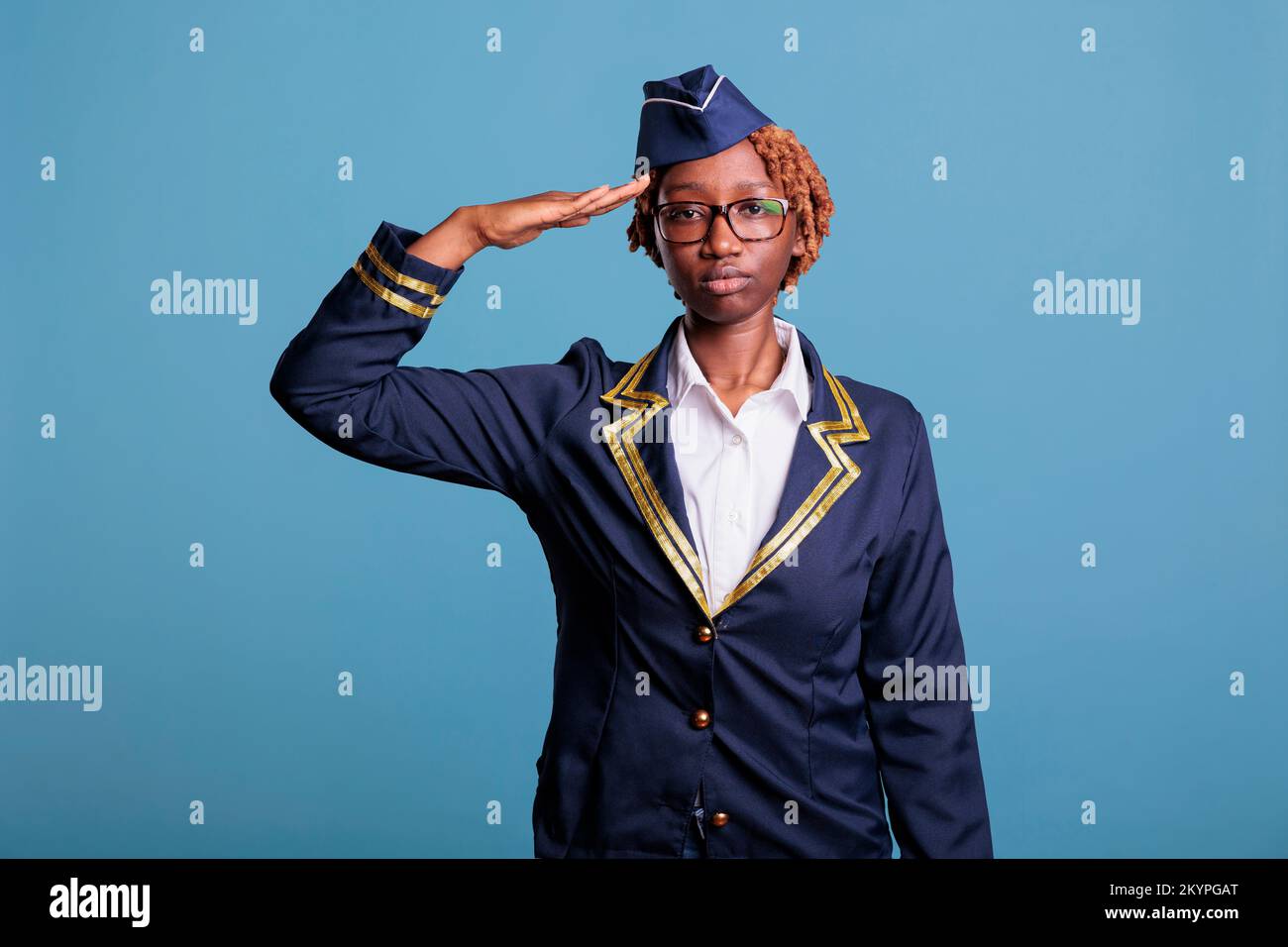Portrait of female airline stewardess waving dressed in airline uniform ...