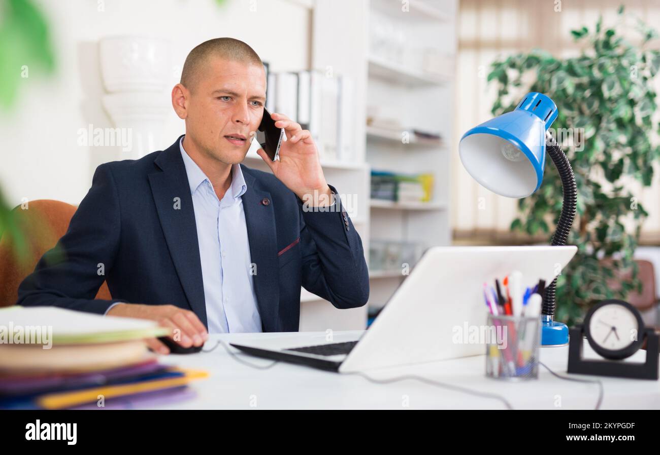 Businessman is talking phone with partner in office Stock Photo - Alamy