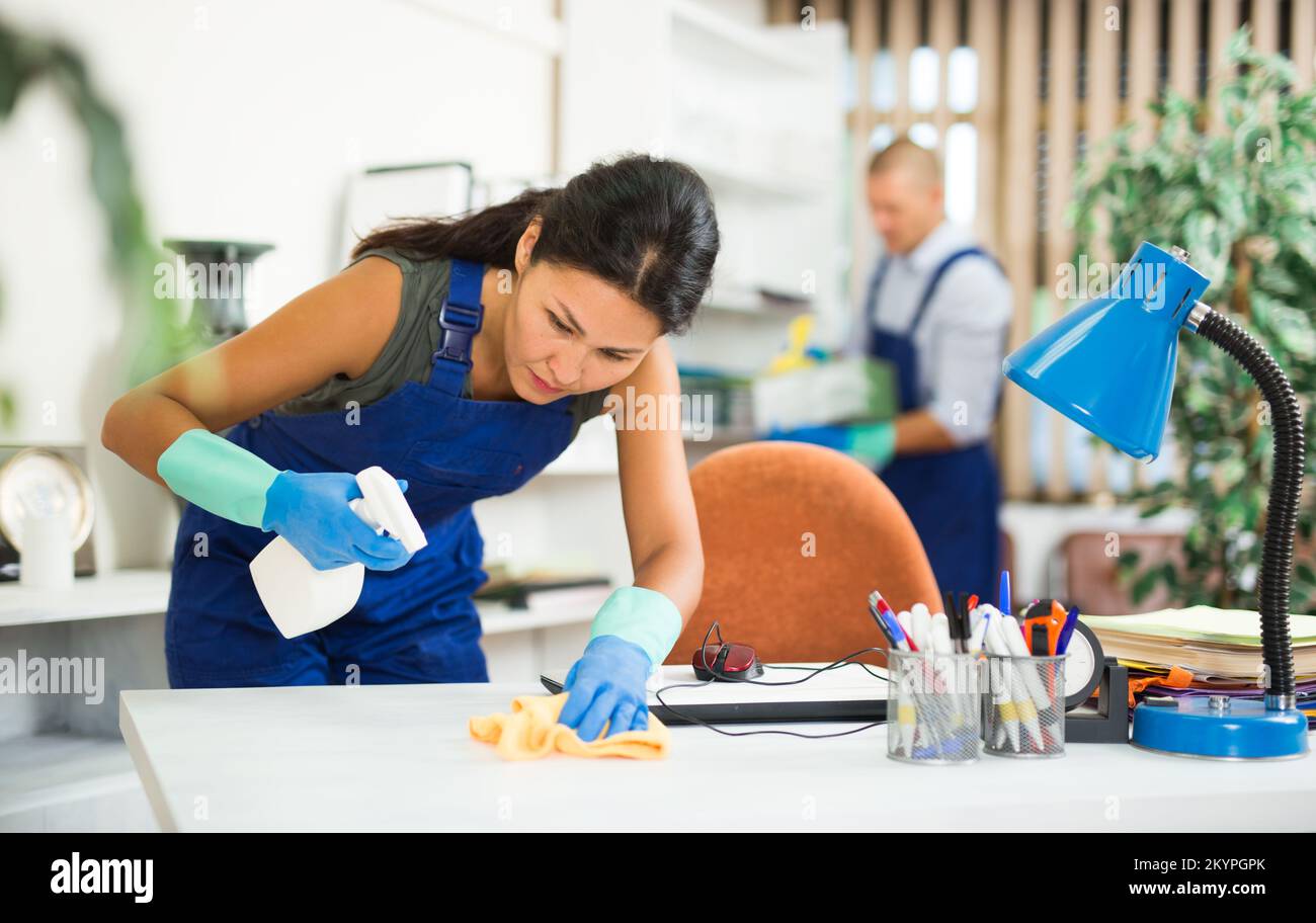 Asian female cleaning desk in office Stock Photo - Alamy