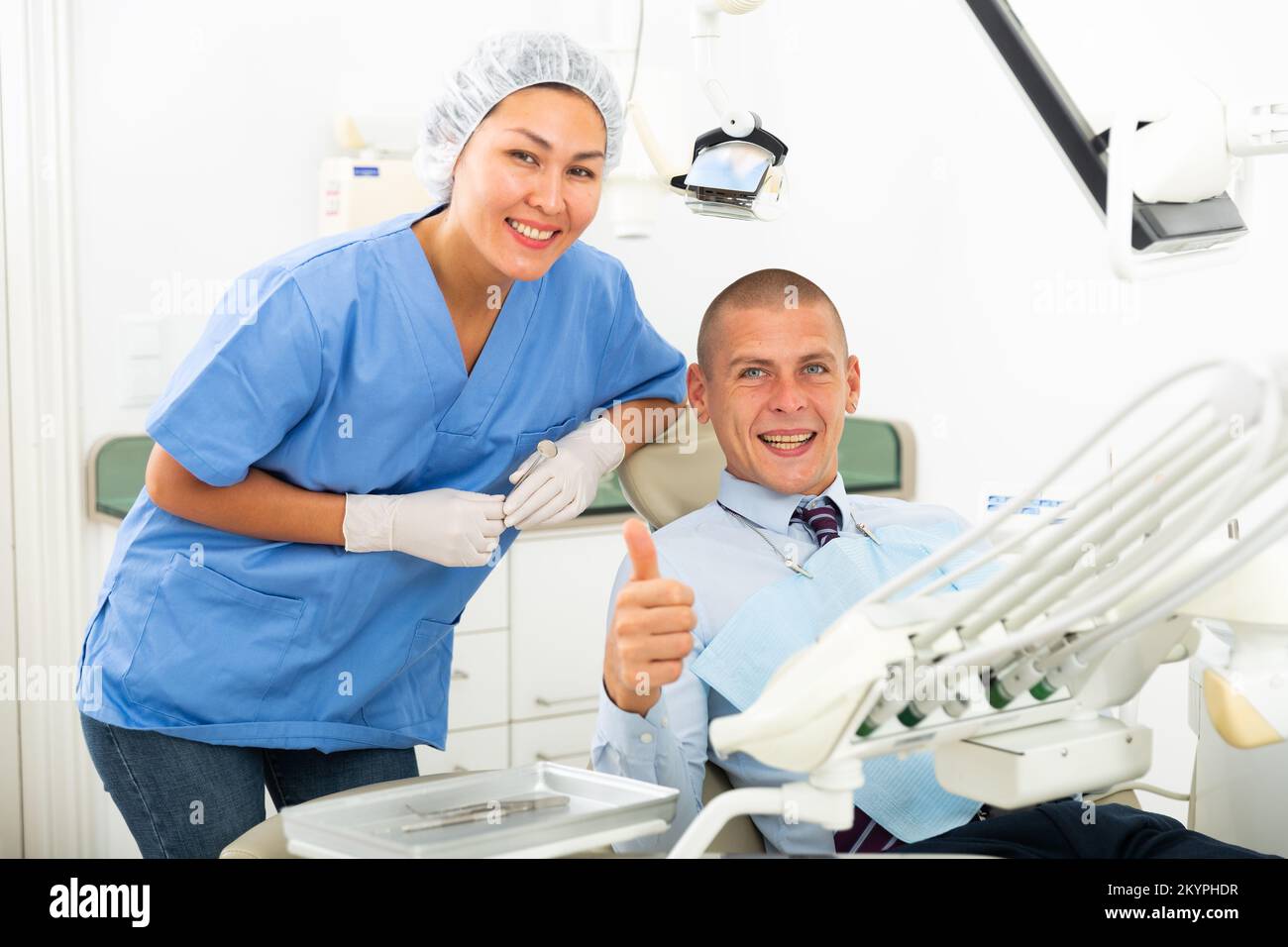 Satisfied patient visiting dentist giving thumbs up Stock Photo - Alamy