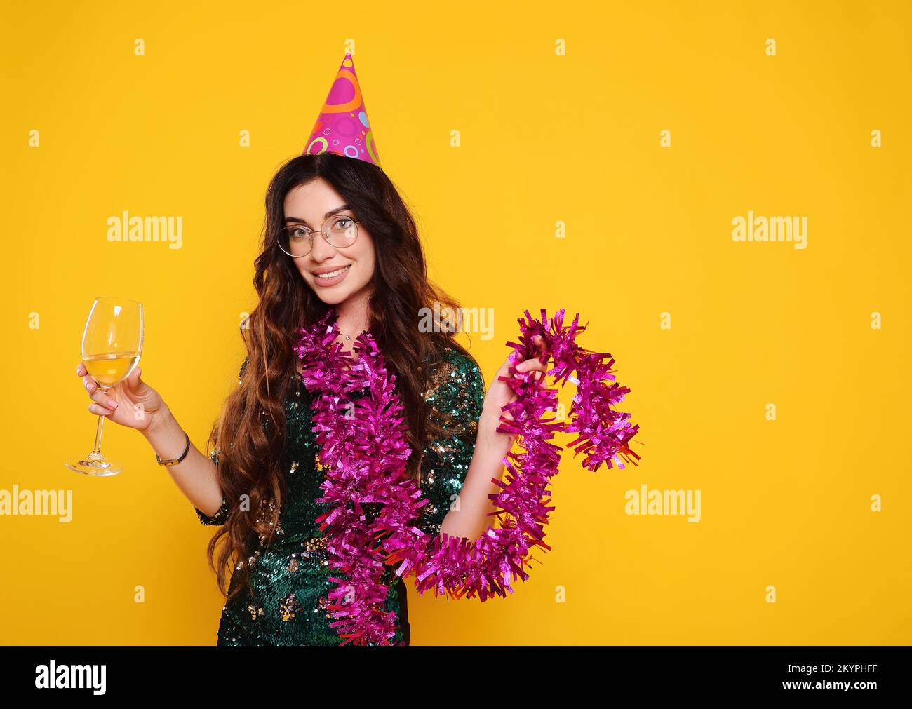 woman in a smart dress in a party cap with a pink boa around her neck ...