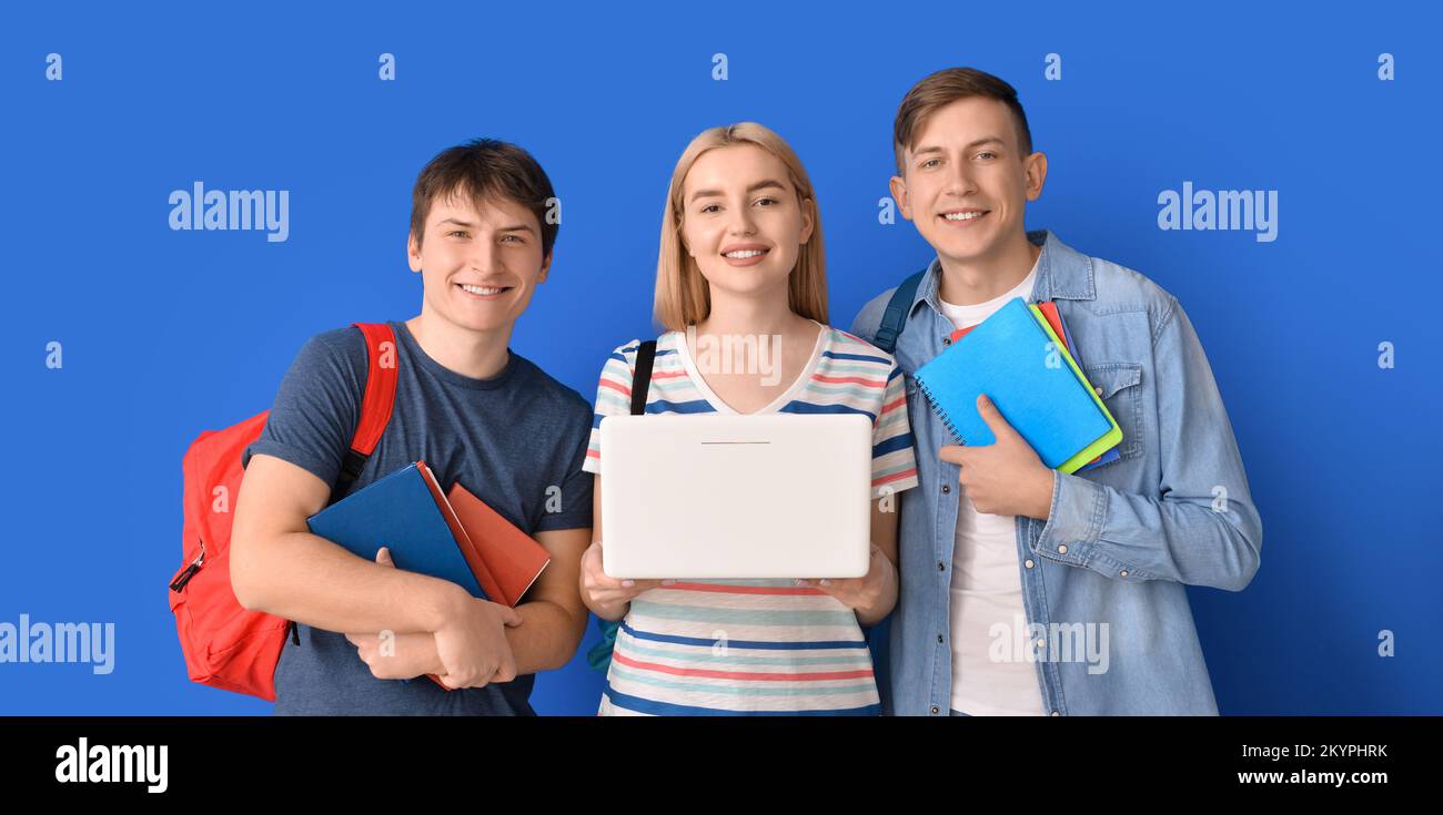 Students with laptop on blue background Stock Photo - Alamy