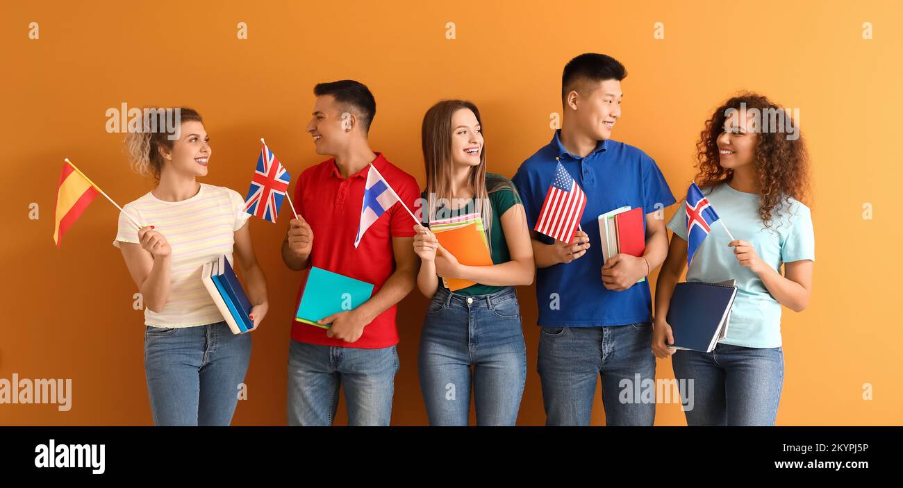Young students of language school on orange background Stock Photo - Alamy