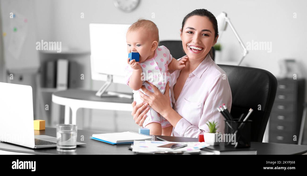 Working mother with her little baby in office Stock Photo - Alamy