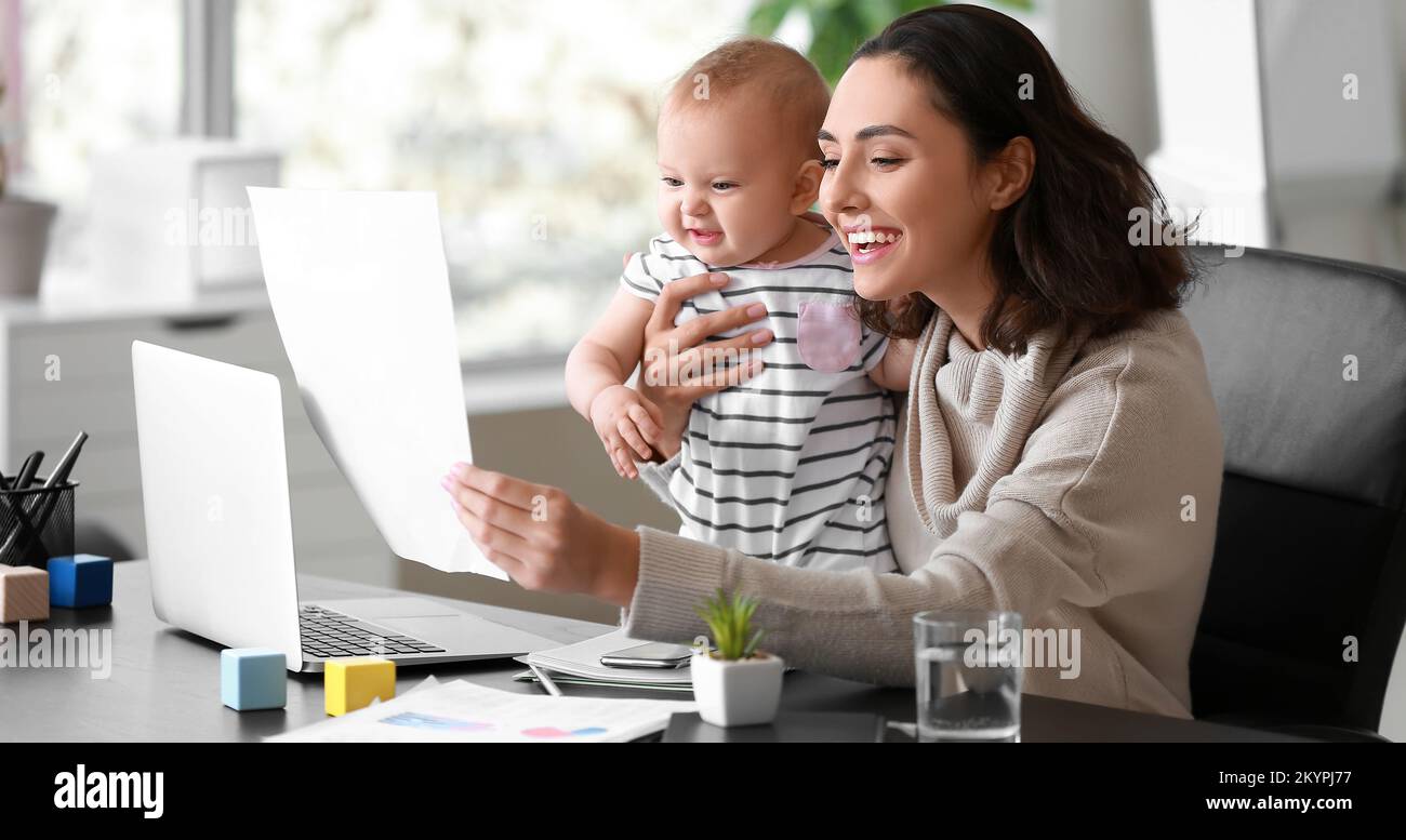 Happy working mother with her baby in office Stock Photo - Alamy