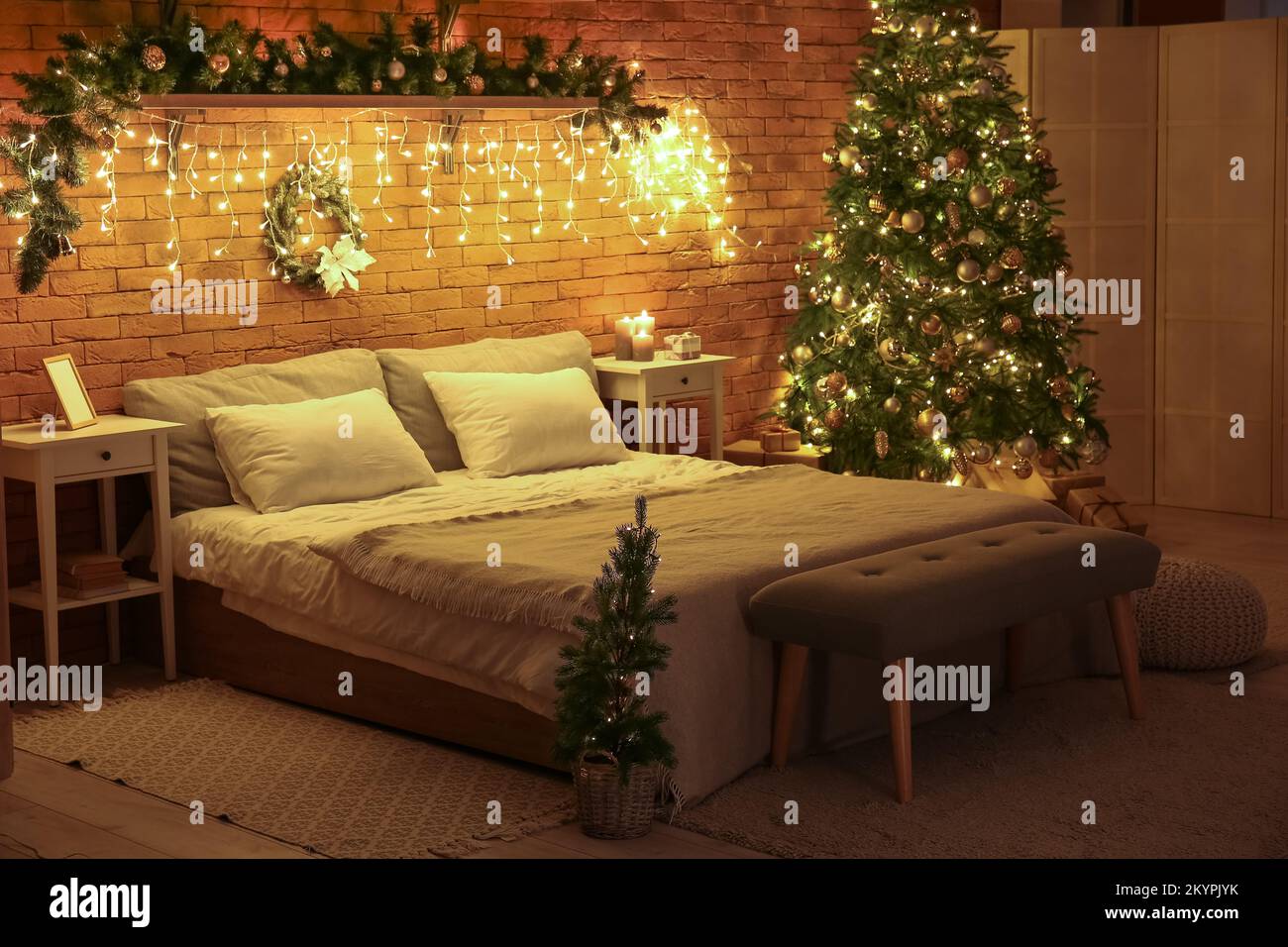 Interior of dark bedroom with Christmas trees, fir branches and glowing ...