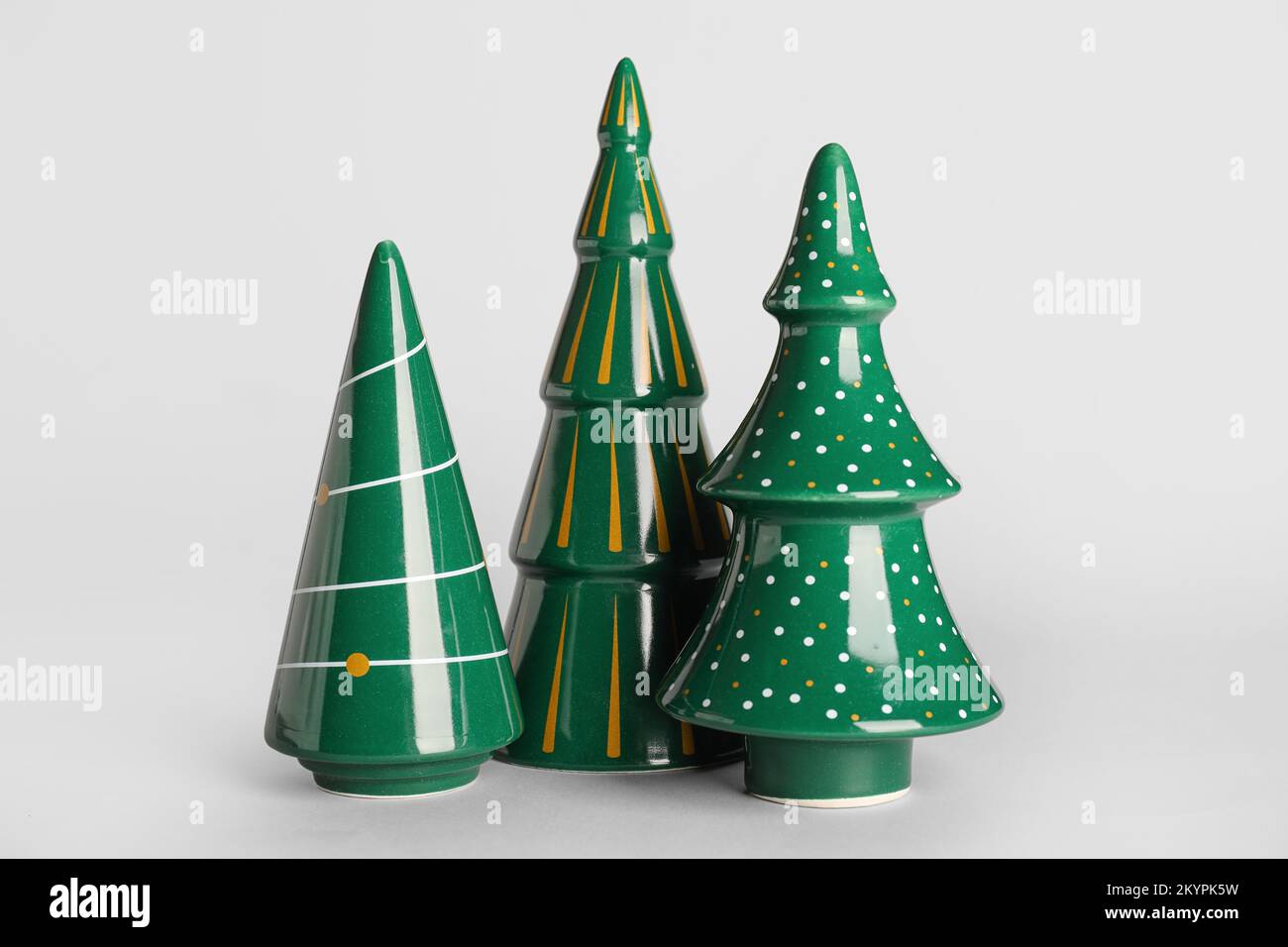 Beautiful ceramic Christmas trees on light background Stock Photo - Alamy