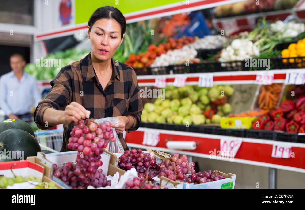 Woman buying grape in market hi-res stock photography and images - Alamy