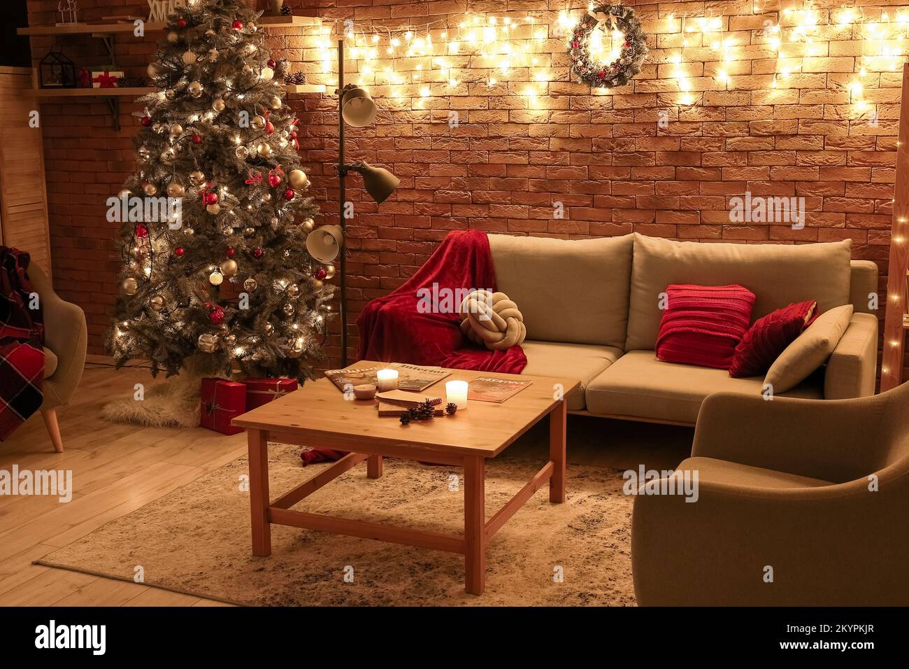 Interior of living room with sofa, Christmas tree and glowing lights at ...