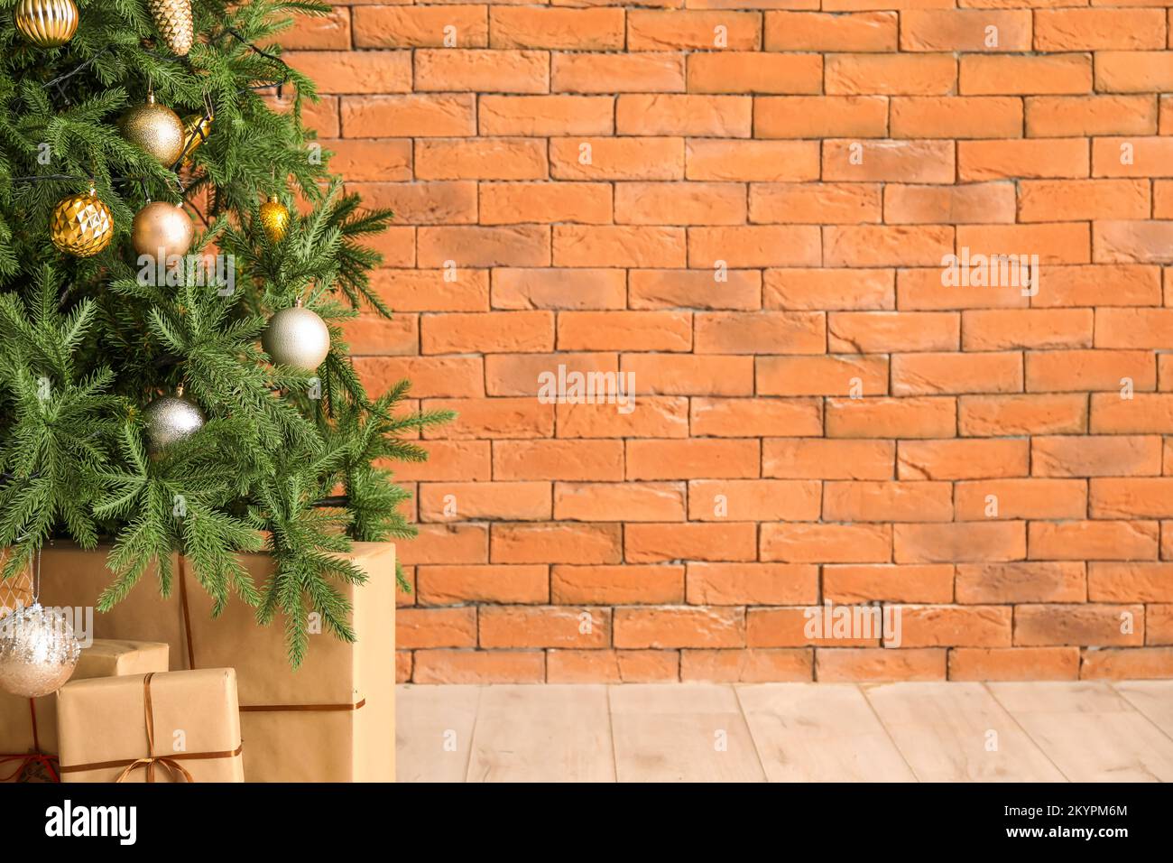 Decorated Christmas tree with presents near brick wall Stock Photo - Alamy