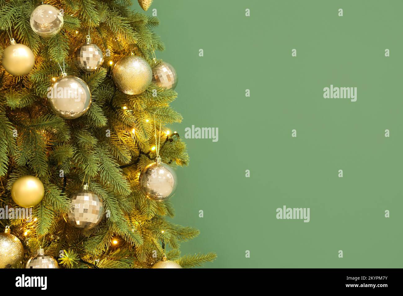 Glowing Christmas tree near green wall, closeup Stock Photo - Alamy