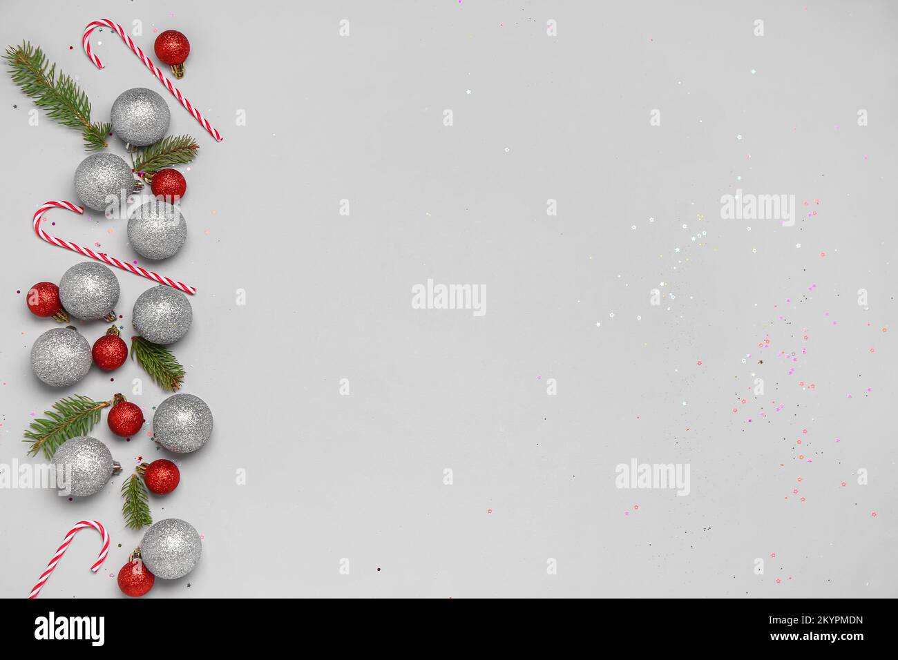 Christmas balls with fir branches and candy canes on grey background ...