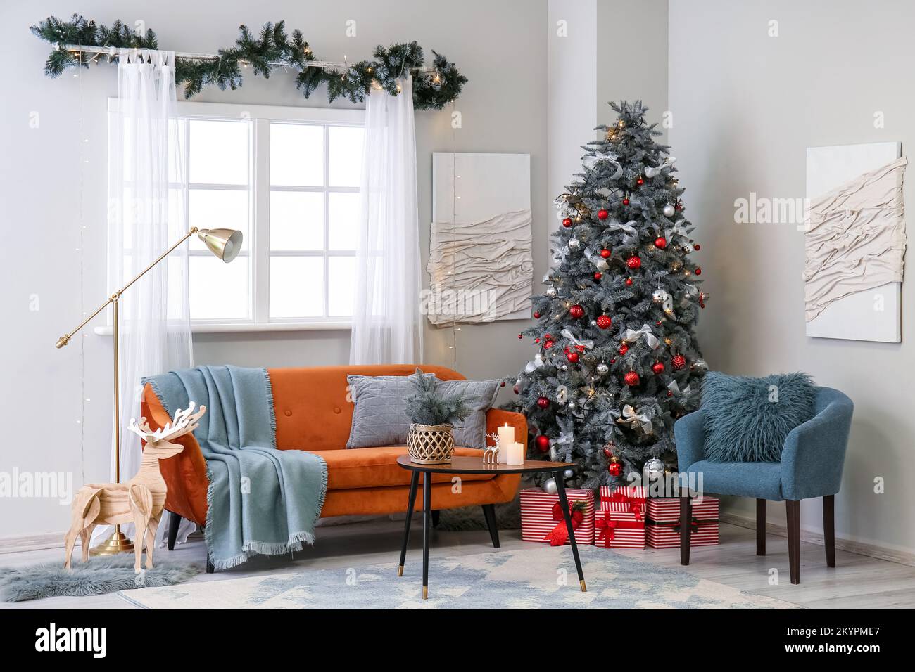 Interior of living room with big Christmas tree, sofa and armchair ...