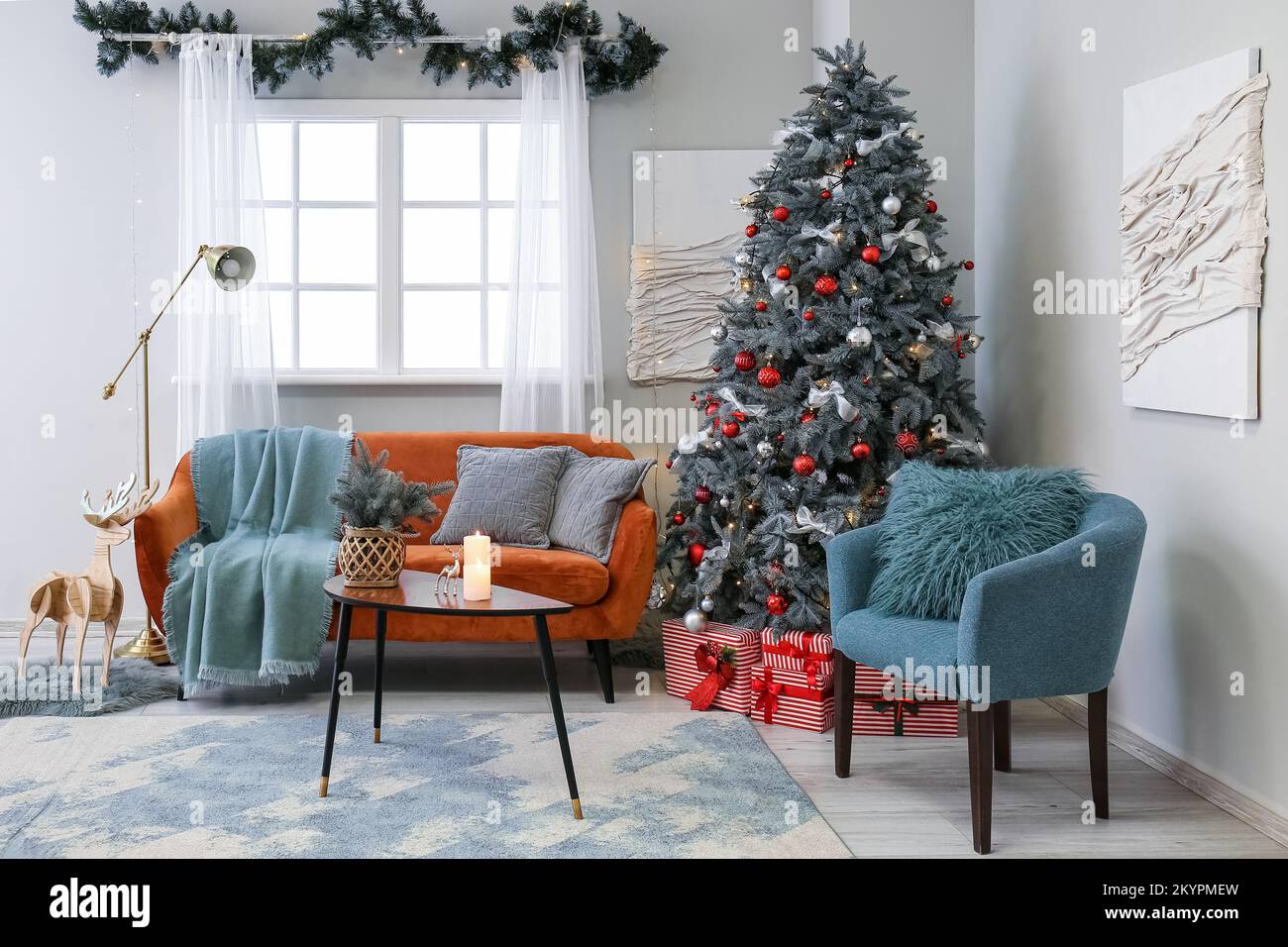 Interior of living room with big Christmas tree, sofa and armchair ...