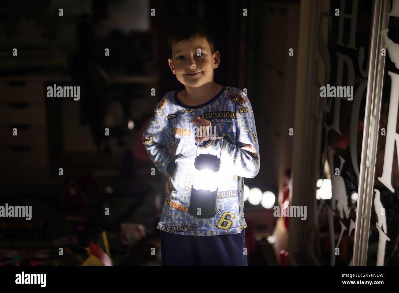 Boy at home during a blackout using flashlight lantern Stock Photo - Alamy