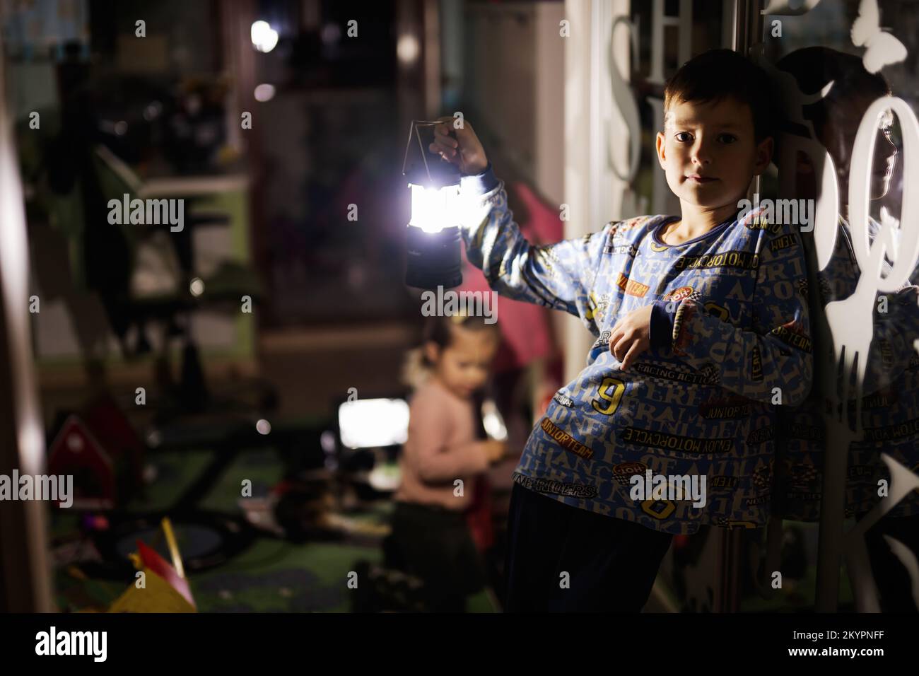 Boy at home during a blackout using flashlight lantern Stock Photo - Alamy