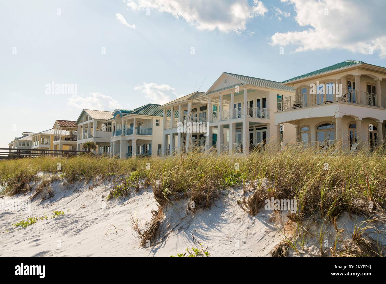 Destin, Florida- White sand dunes with grasses at the front of three ...