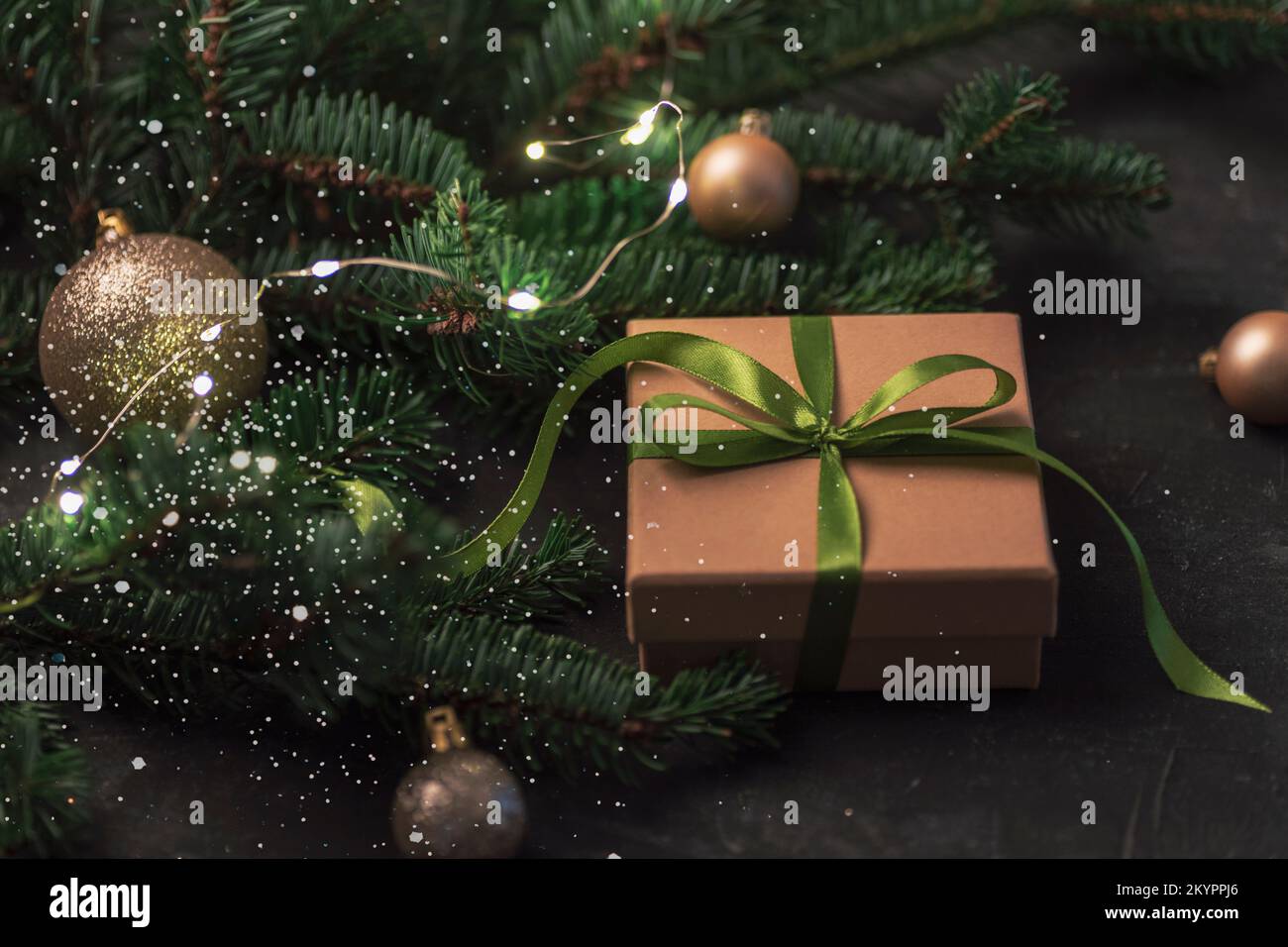 Gift box, Christmas baubles, fir tree and Christmas lights on black ...