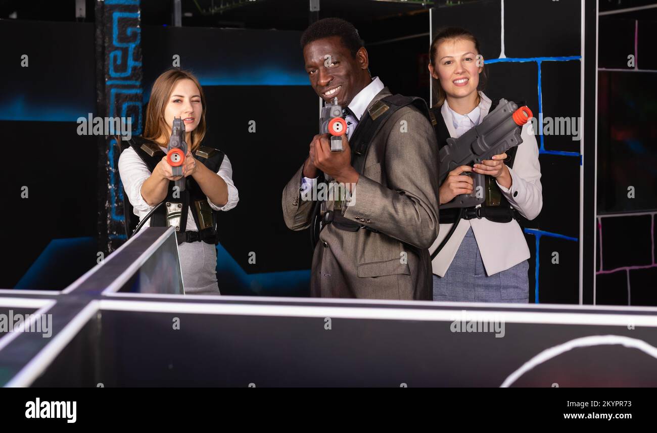 African man and two glad female at laser tag room Stock Photo - Alamy
