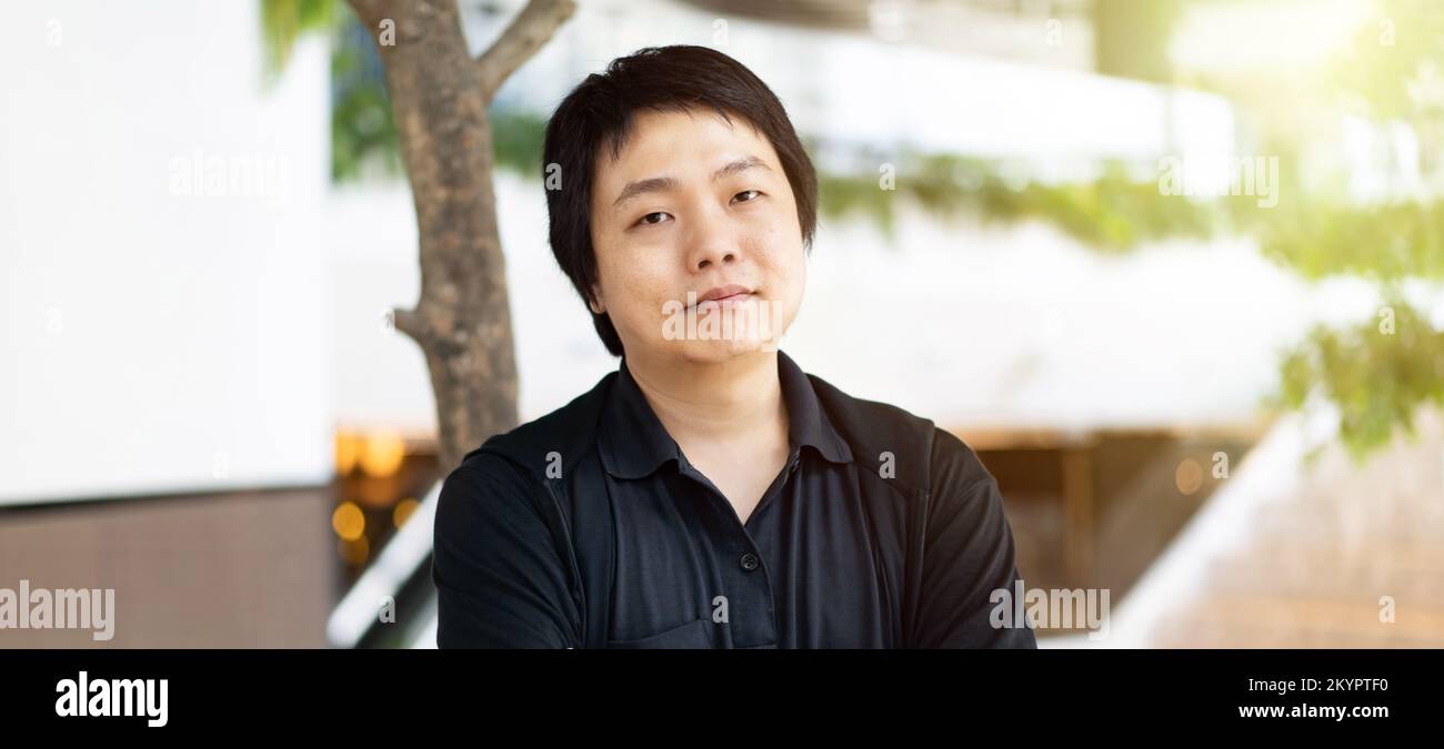 The portrait of Asian man in a black casual shirt with crossed arms ...