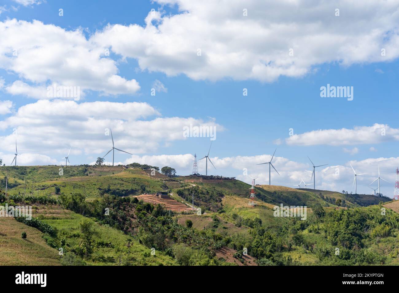 The wind turbines in the top of the grass hill underneath the group of ...
