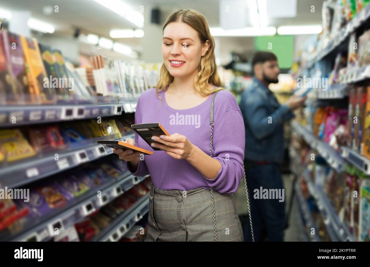 Smiling girl choosing tasty chocolate Stock Photo - Alamy
