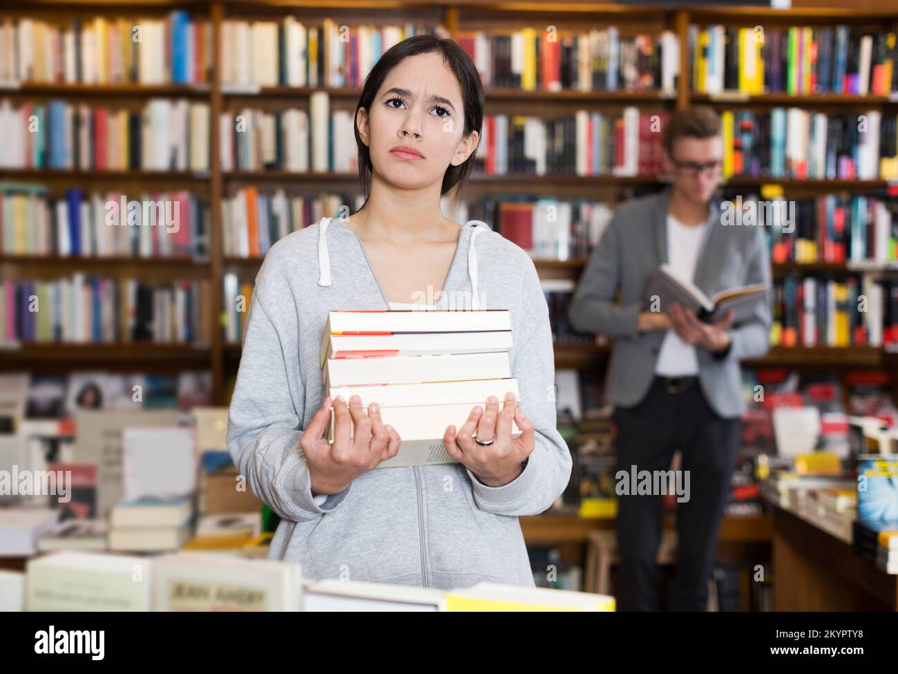 Sad girl holding pile of books Stock Photo - Alamy