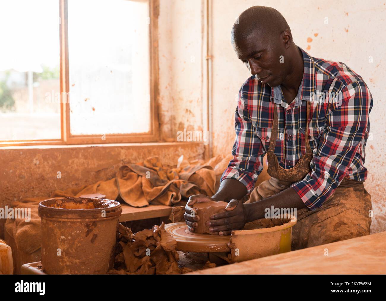 Man focused on work on pottery wheel Stock Photo - Alamy