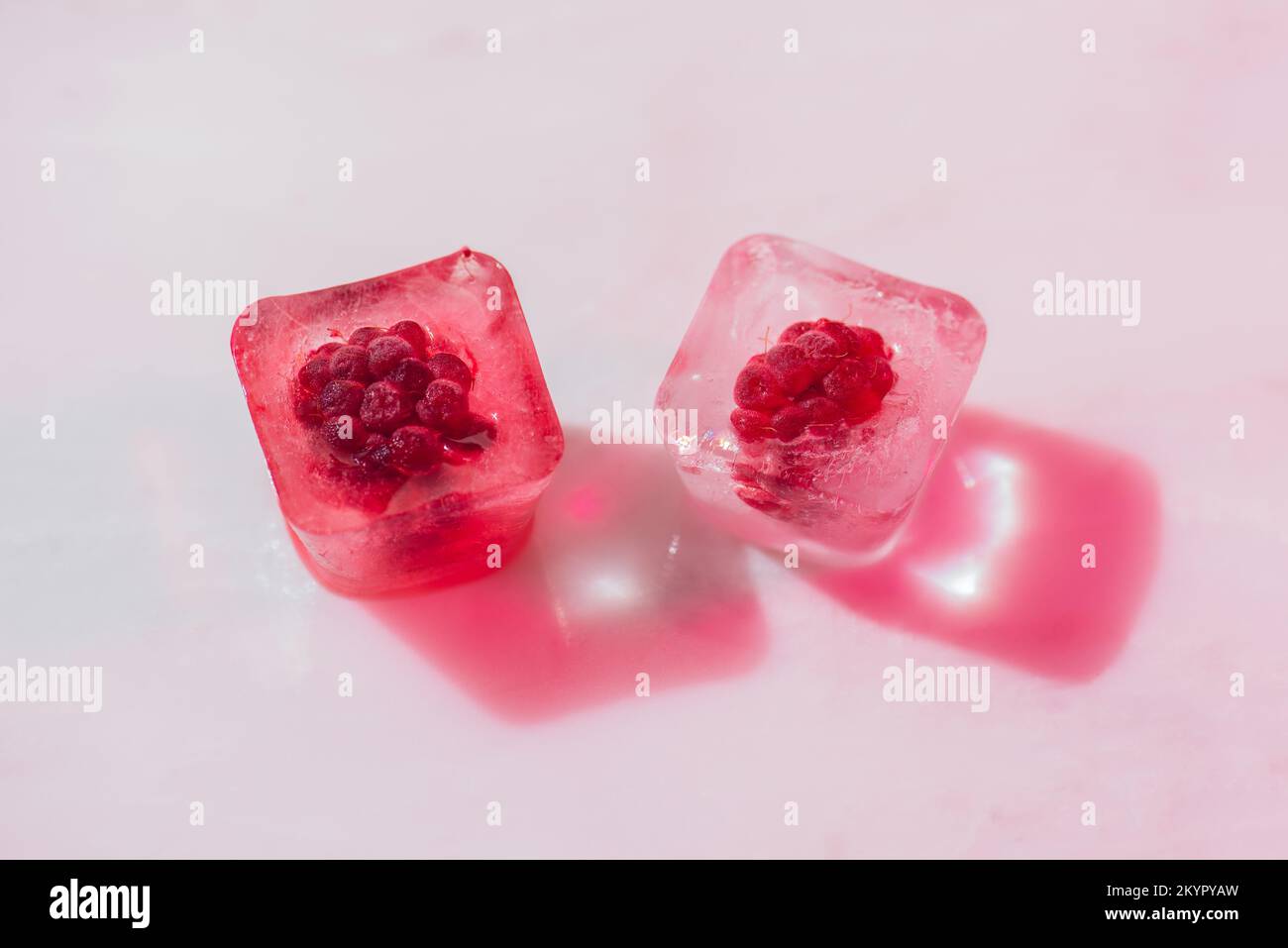 Frozen Raspberry in Ice Cube, Close-up in White Marble Surface Stock ...
