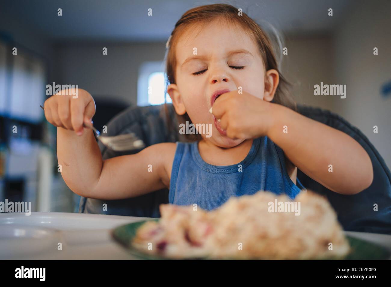 Young cute baby enjoy self eating meal with hands, healthcare and ...