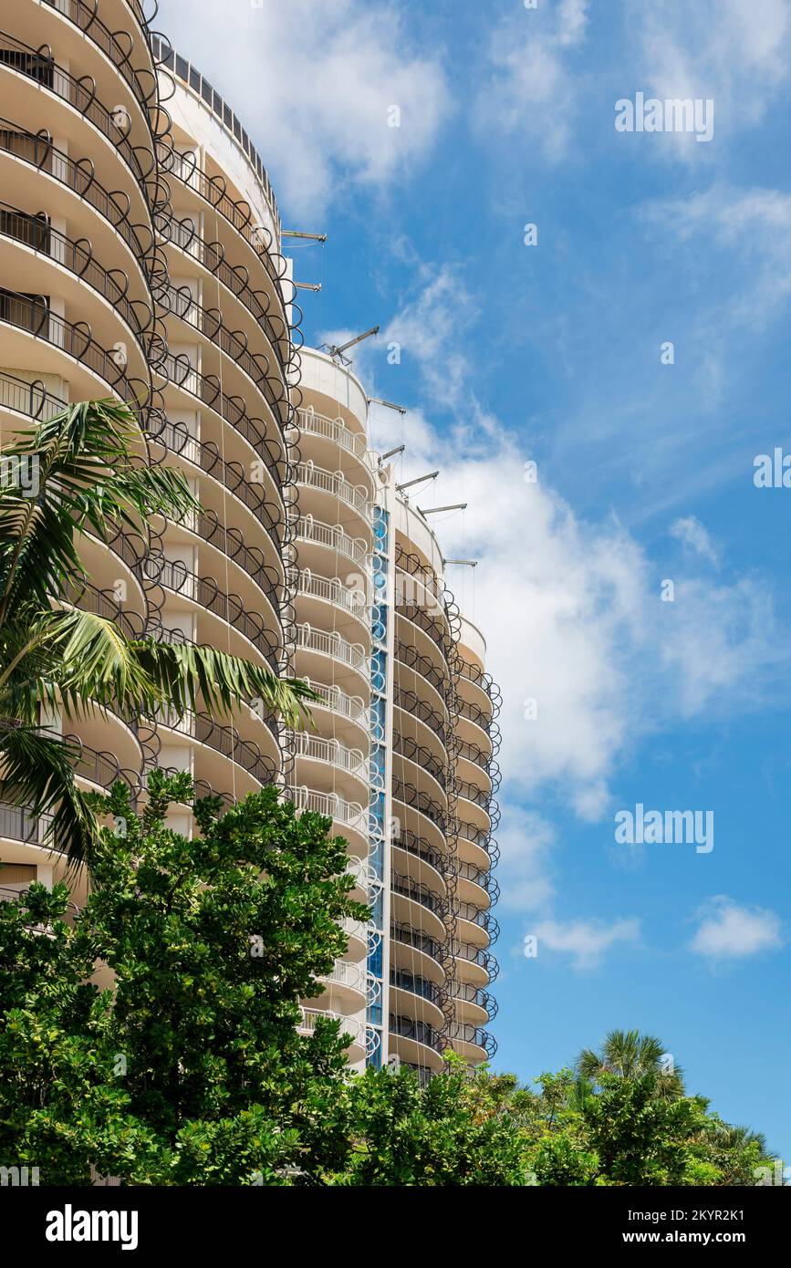 View of a condominium with curved walls and balcony railings from below ...