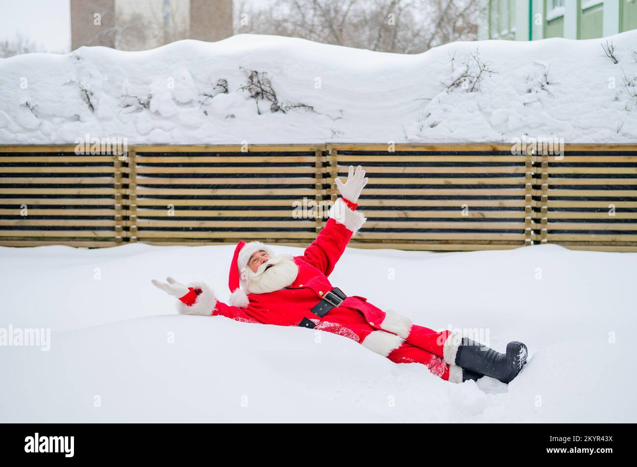 Happy santa claus lying in the snow and fooling around Stock Photo - Alamy