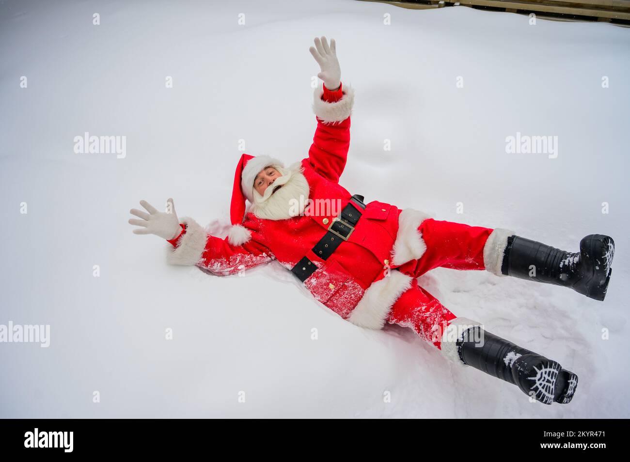 Happy santa claus lying in the snow and fooling around Stock Photo - Alamy