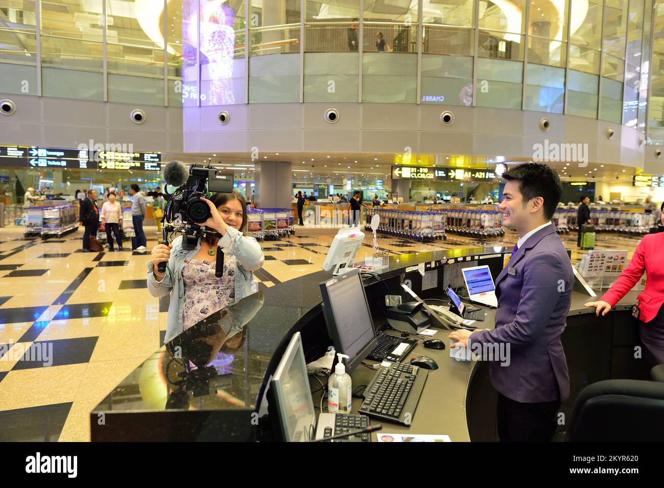 SINGAPORE - NOVEMBER 03, 2015: woman with camera near information desk ...