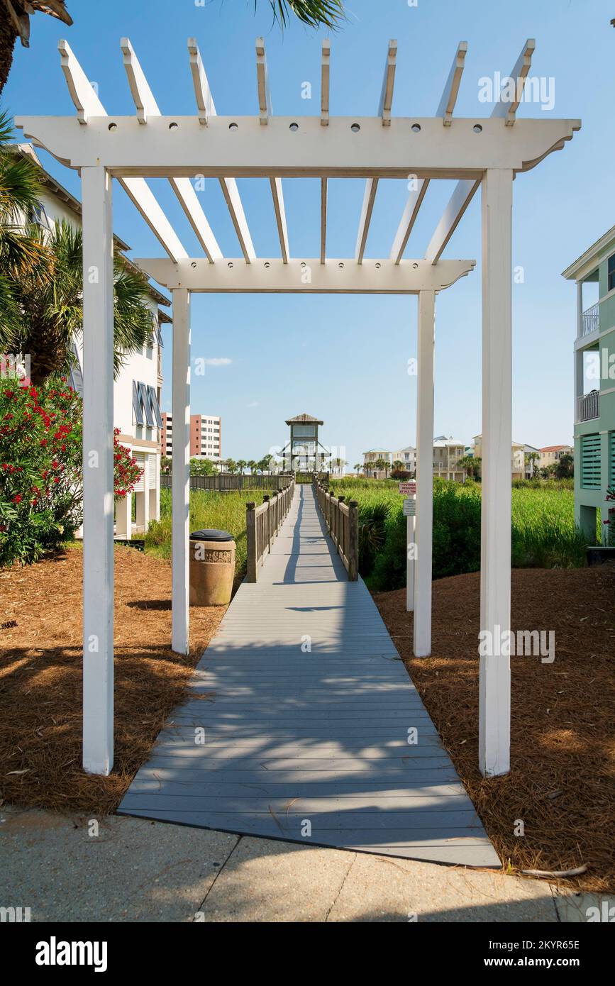Entrance pathway with white pergola heading to a boardwalk over the ...