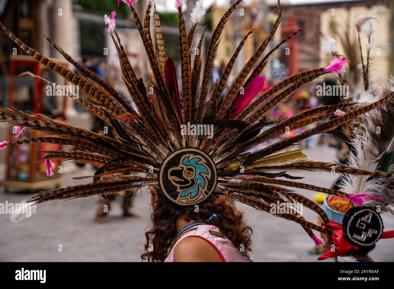 Woman wearing a pheasant feather head dress with an eagle emblem at the ...