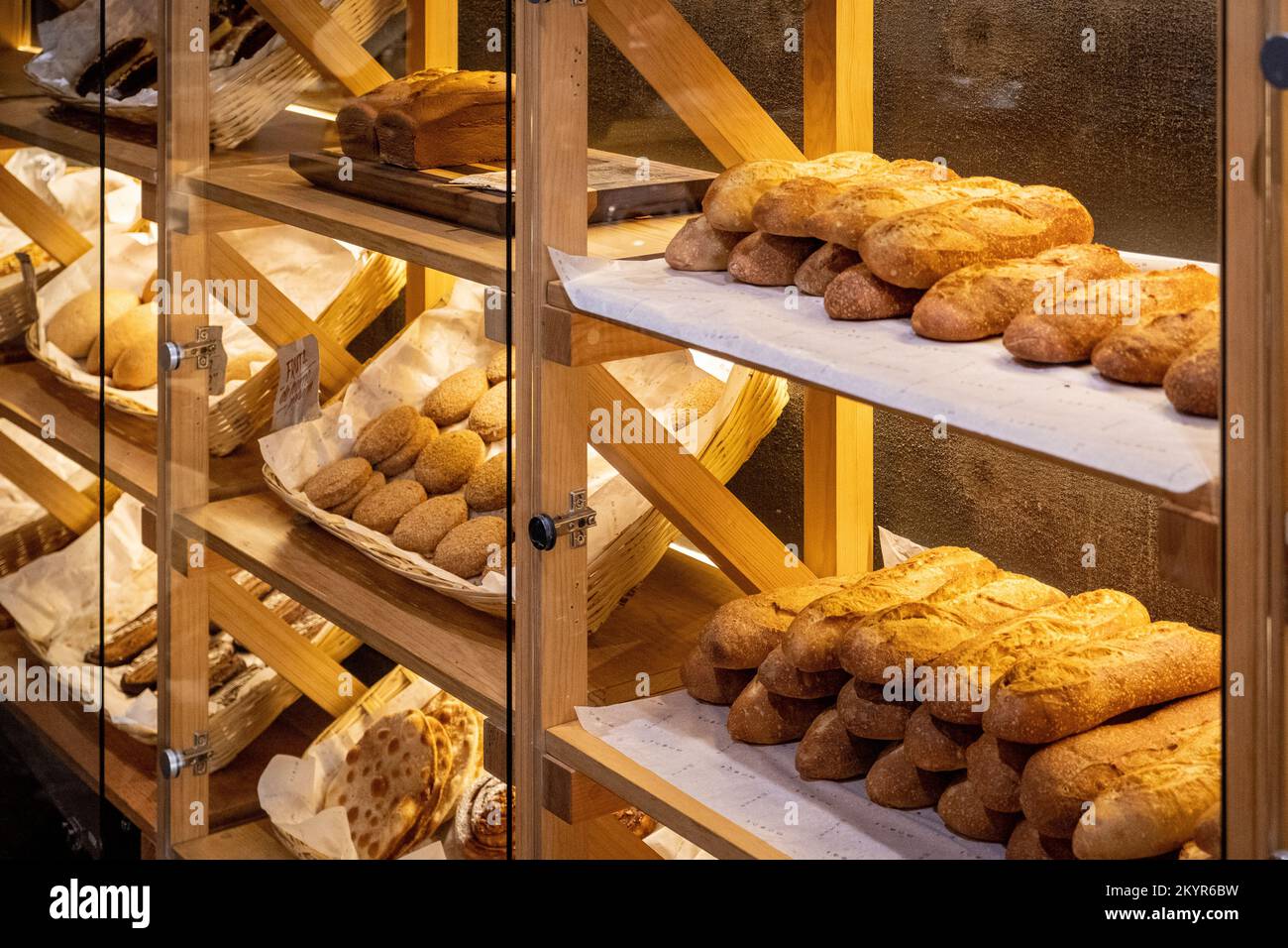 A variety of fresh bread showcased behind glass doors at a European ...